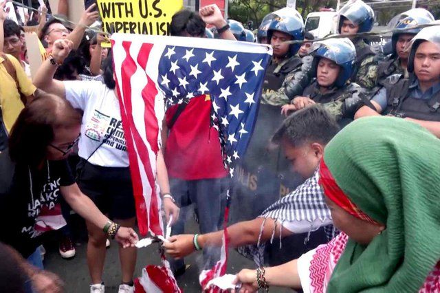 Filipino activists burn US flag in condemnation of US-Israel attacks on ...